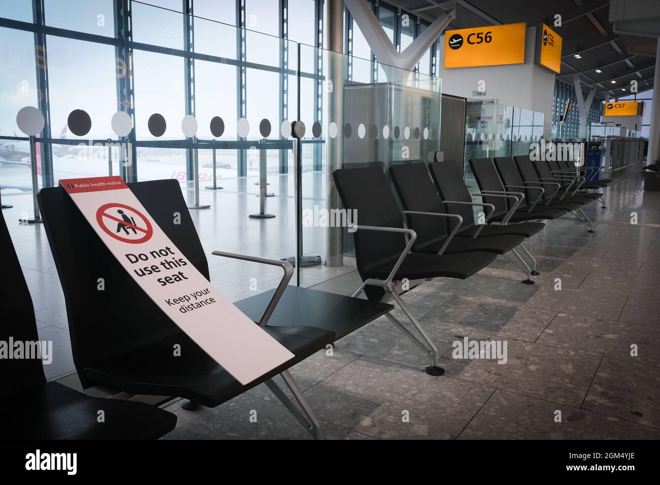 Social distance notice sign on airport terminal chairs. Safety measures ...