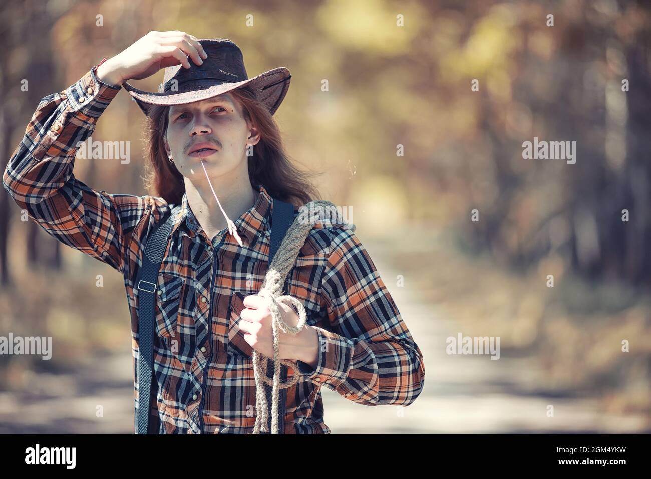 Cowboy with hat in a field in autumn Stock Photo - Alamy
