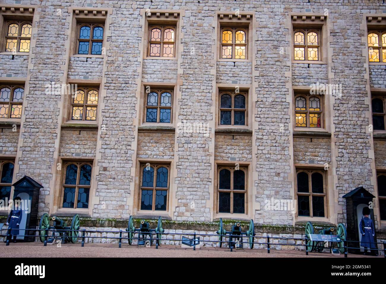 Glowing windows of Tower of London Castle in the evening with two ...