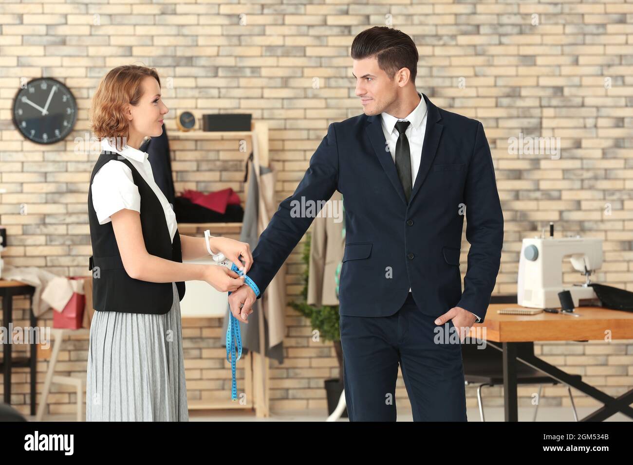 Seamstress taking client's measurements in atelier Stock Photo - Alamy