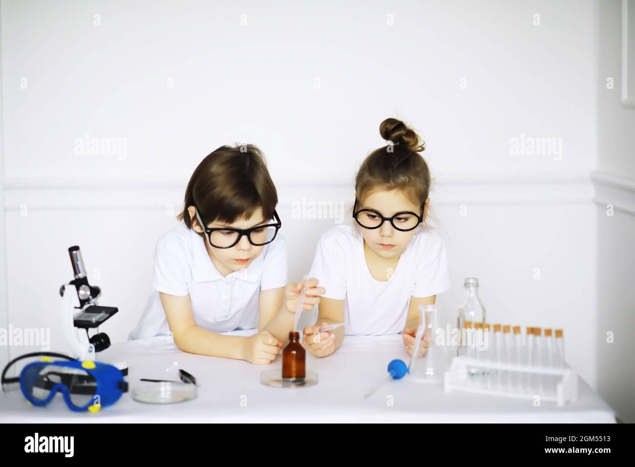 Two cute children at chemistry lesson making experiments isolated on ...