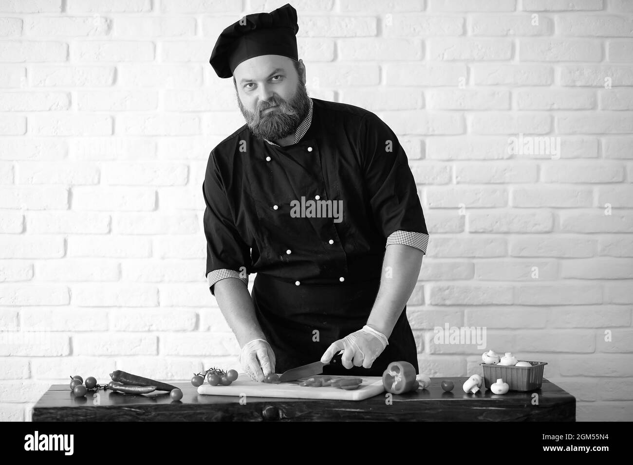 Bearded chef chef prepares meals at the table in the kitchen Stock ...