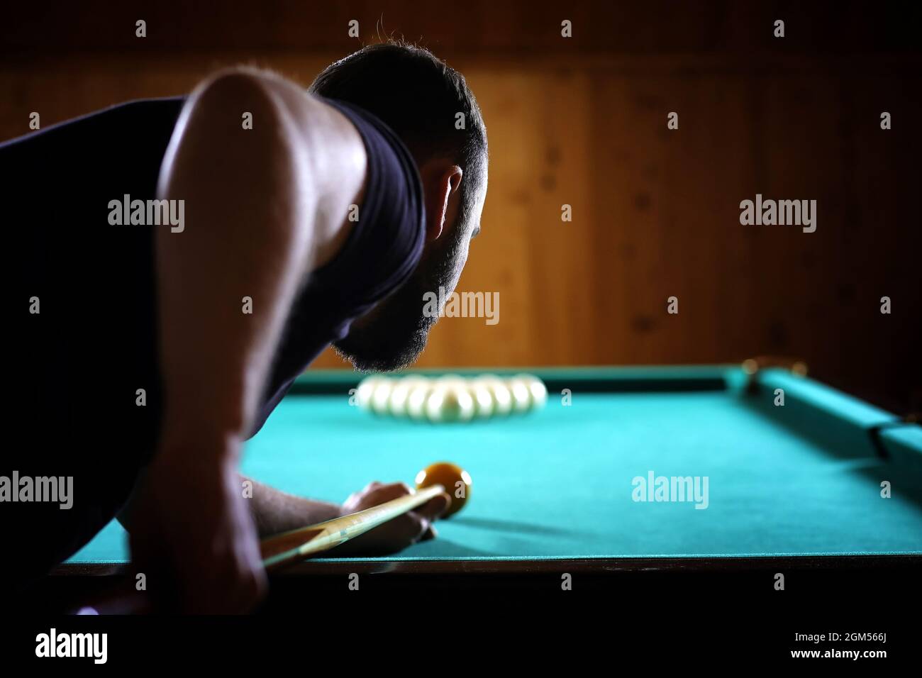 A man with a beard plays a big billiard. Party in 12-foot pool ...