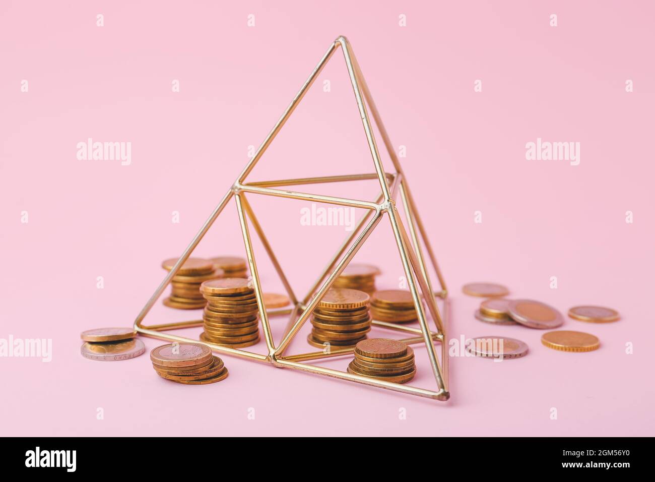 Golden coins with pyramid on color background Stock Photo - Alamy