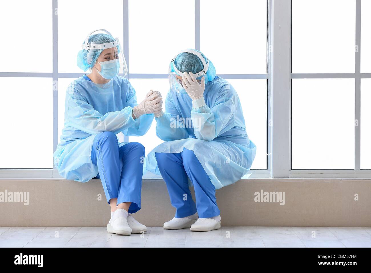 Female Asian surgeon calming her colleague in clinic Stock Photo - Alamy