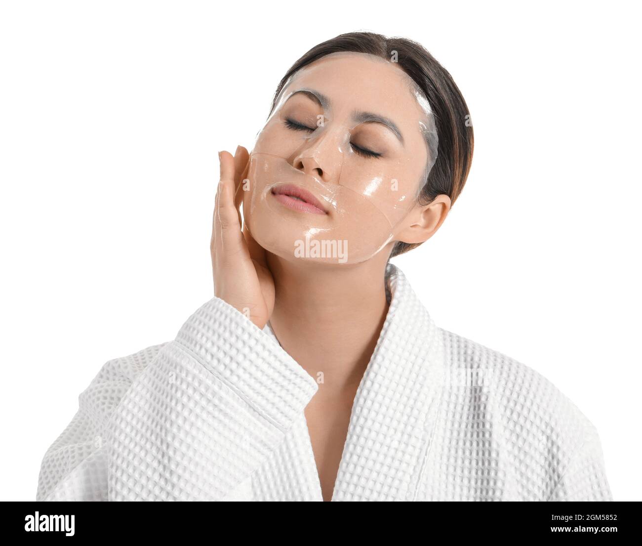 Beautiful young Asian woman with sheet facial mask on white background ...