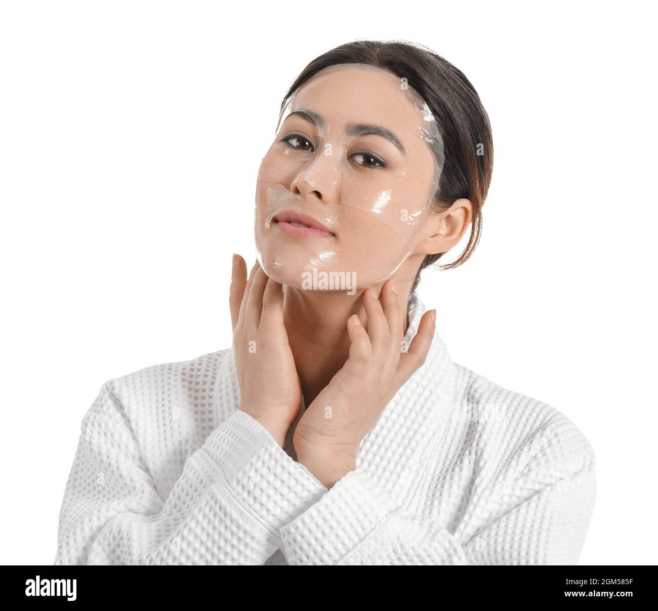 Beautiful young Asian woman with sheet facial mask on white background ...
