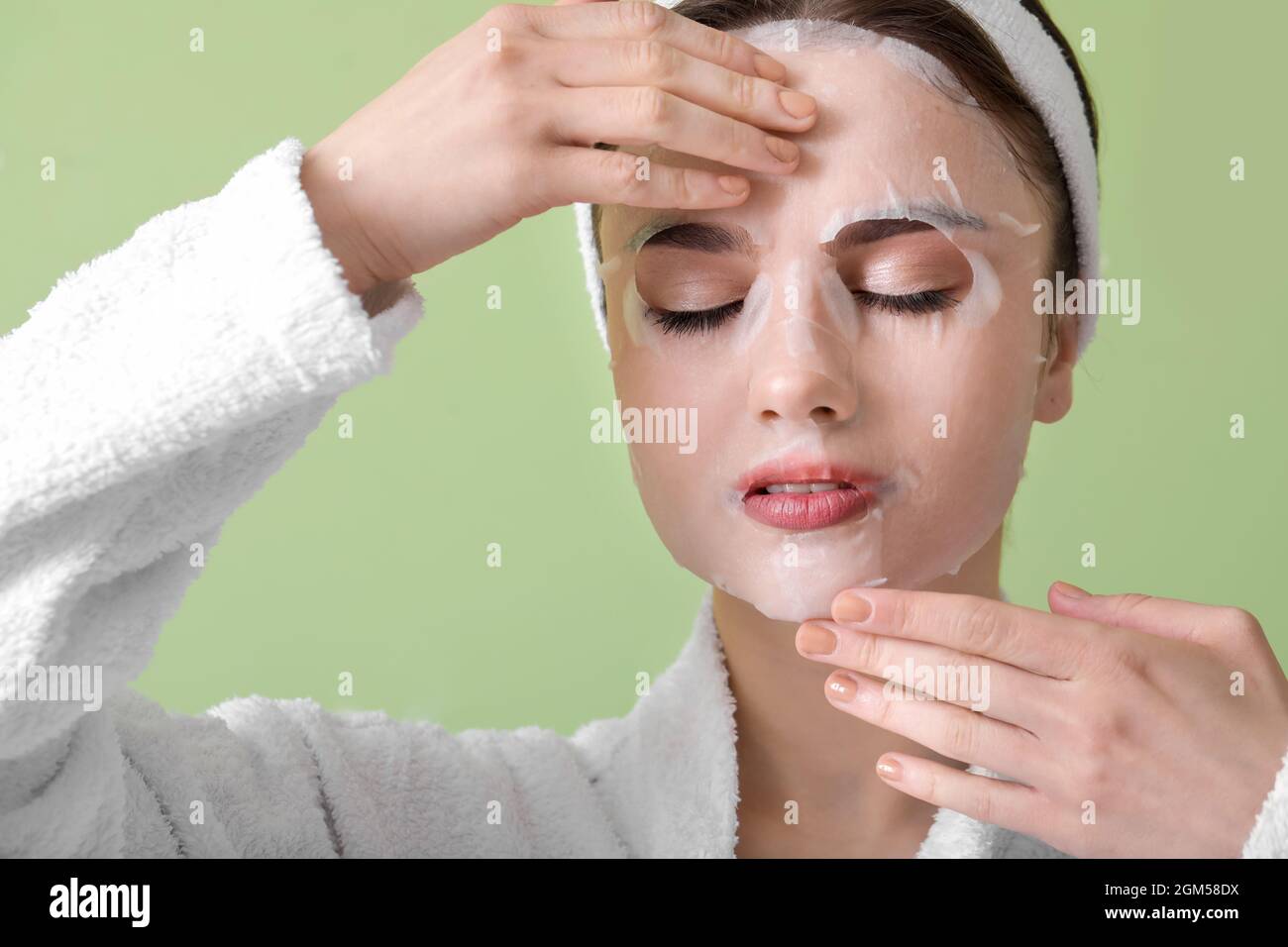 Beautiful young woman with sheet facial mask on color background Stock ...