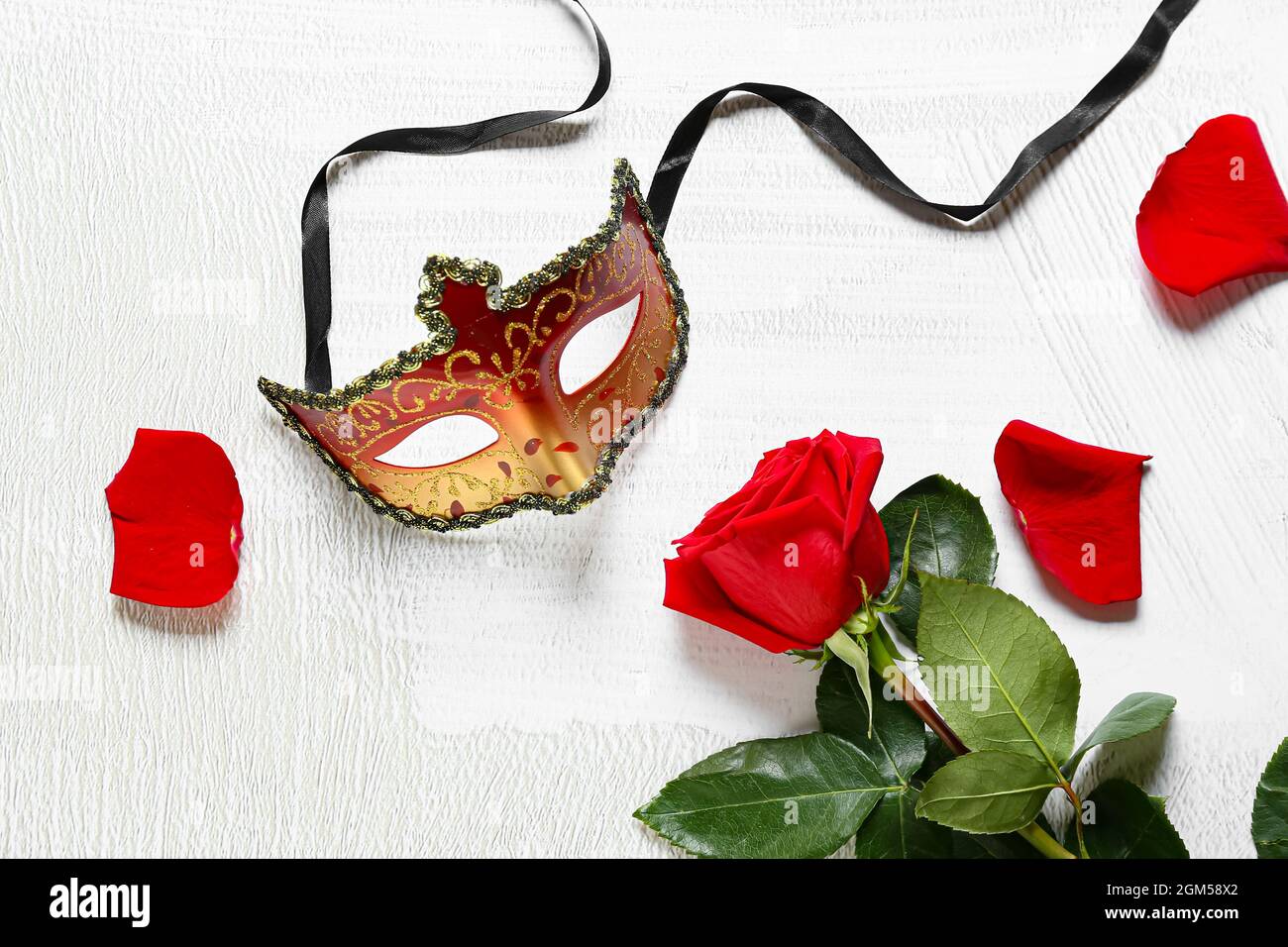 Beautiful rose and masquerade mask on white background Stock Photo - Alamy