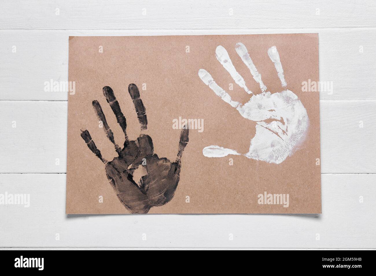 Paper with different handprints on white wooden background. Concept of ...