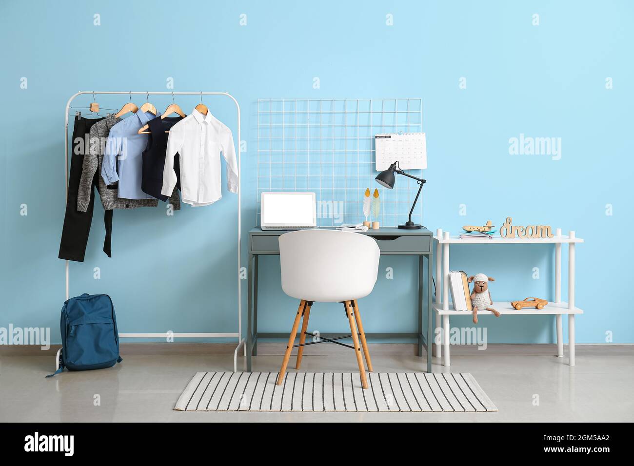 Workplace and rack with school uniform in interior of room Stock Photo ...