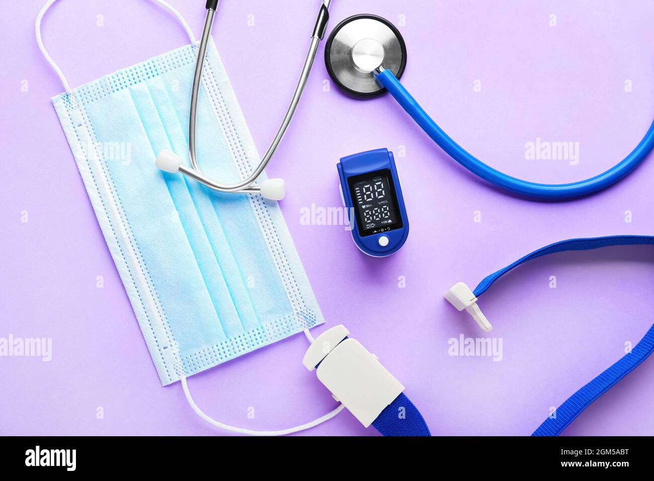 Composition with pulse oximeter and medical mask on color background ...