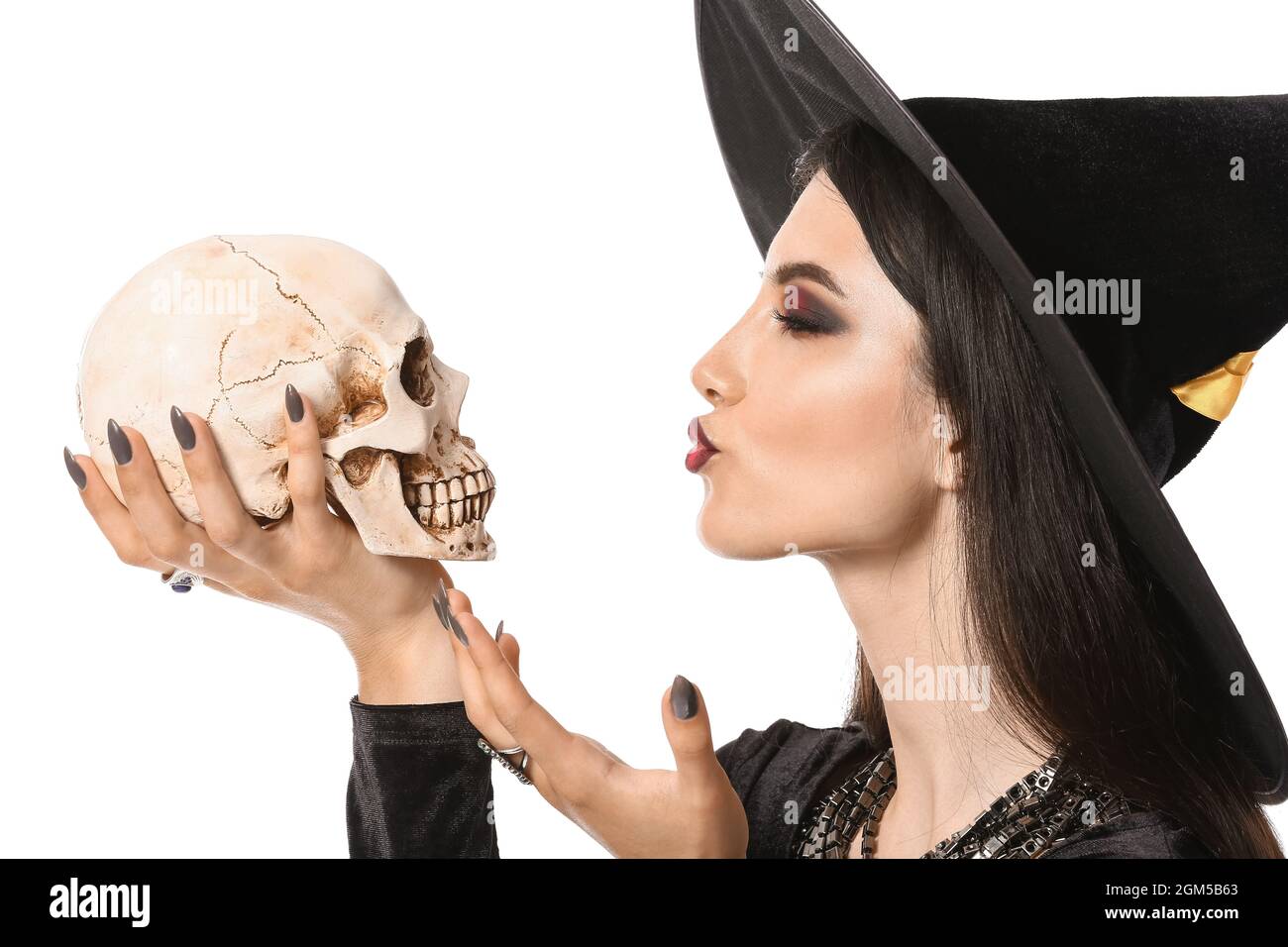 Young witch with human skull on white background Stock Photo - Alamy