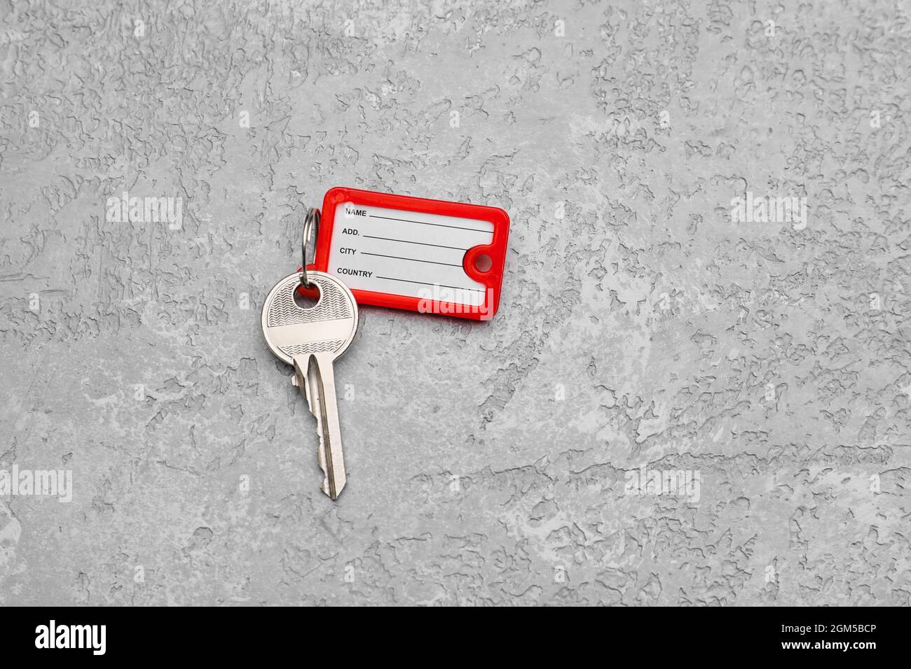 Key with plastic tag on grunge background Stock Photo - Alamy