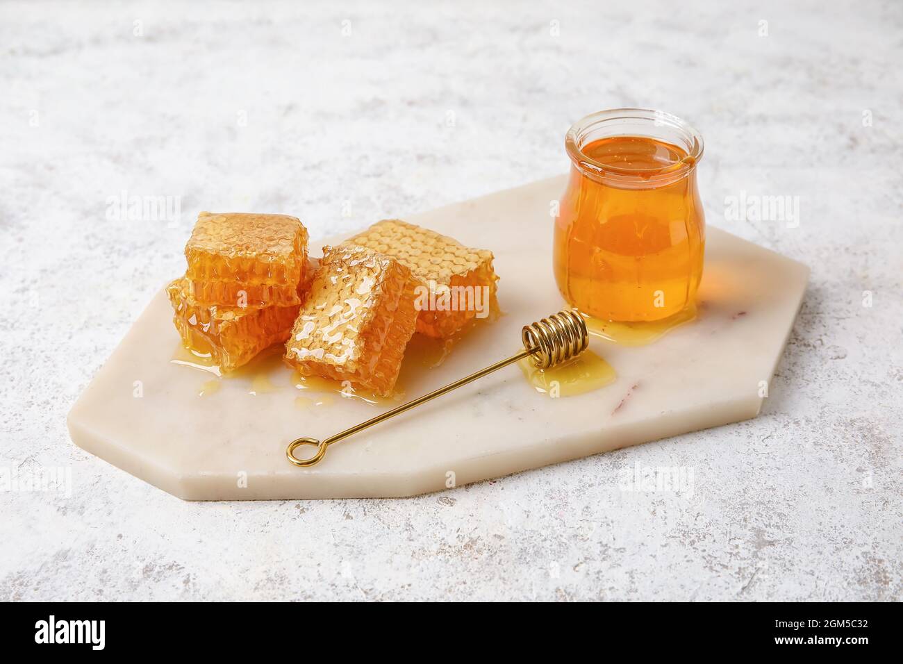 Jar with honey and combs on light background Stock Photo - Alamy