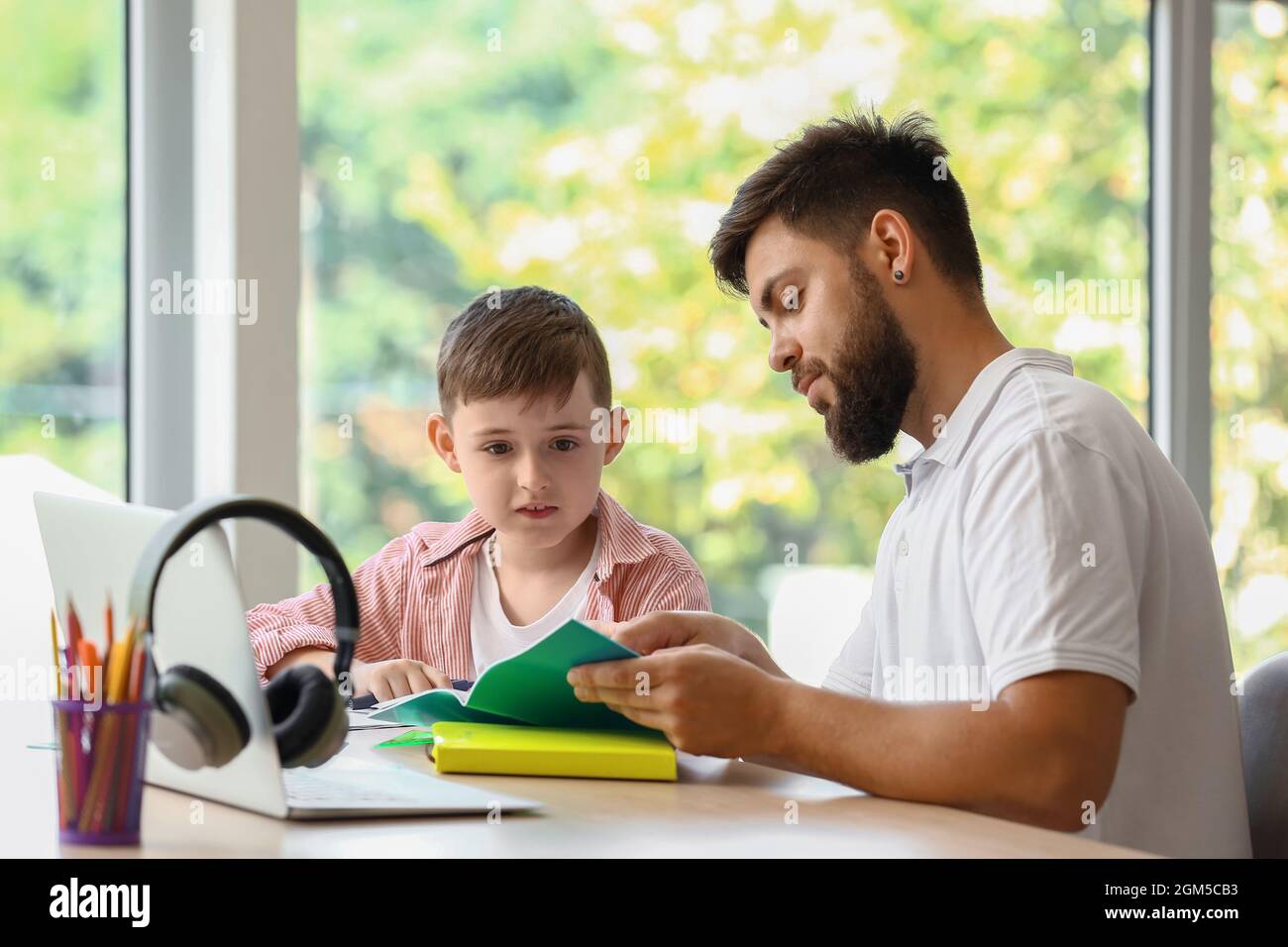 Little boy with his father doing lessons at home Stock Photo - Alamy