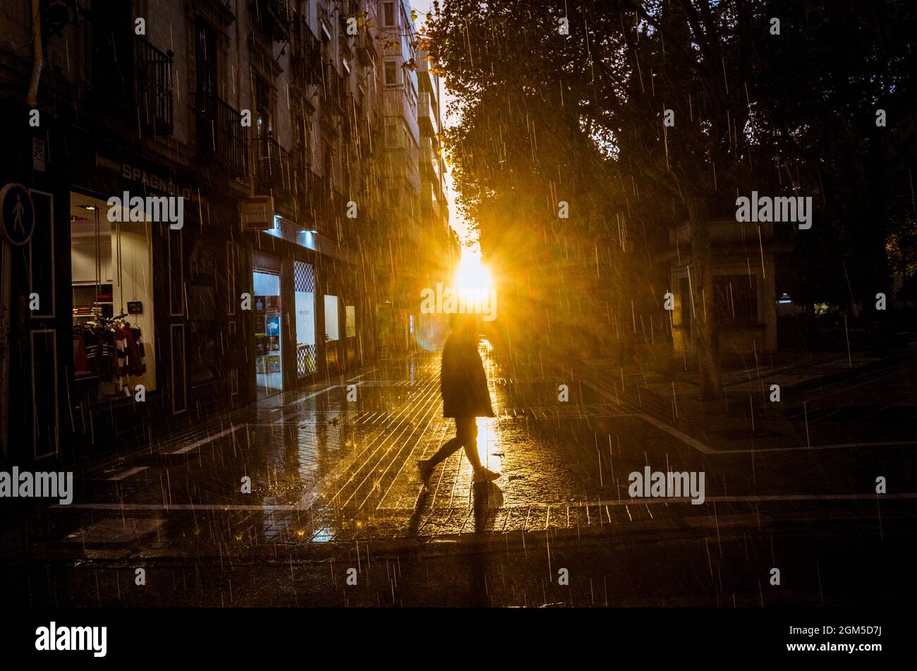 Backlit of a man walking at sunset on a rainy day. Granada, Spain Stock ...