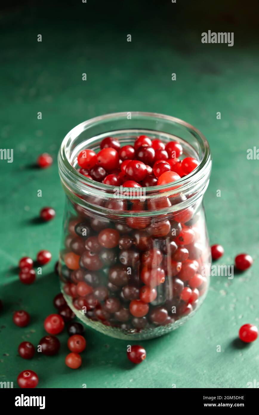 Jar with healthy cranberries on color background Stock Photo - Alamy