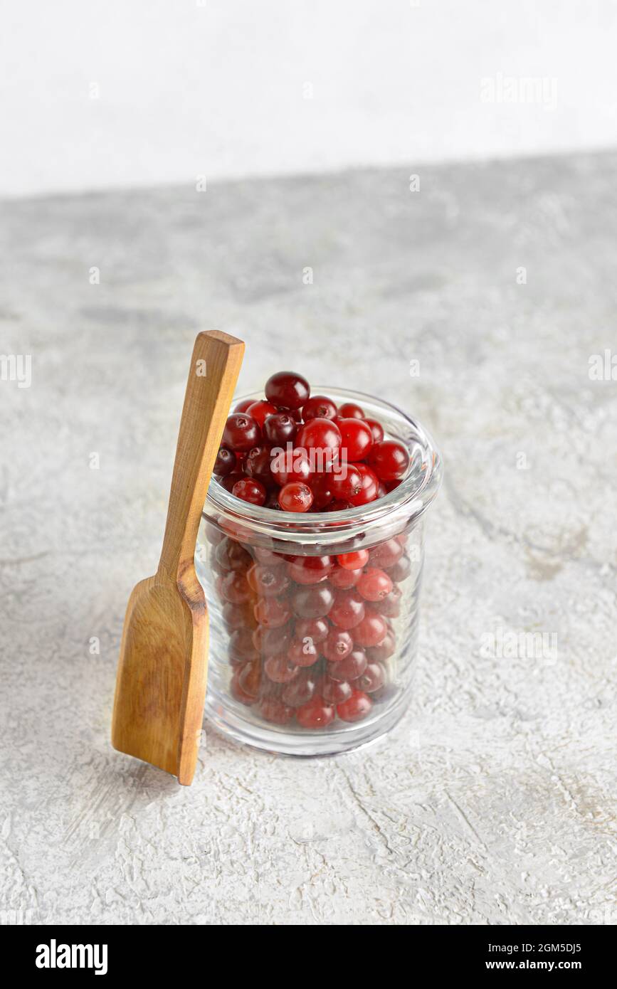 Jar with healthy cranberries on light background Stock Photo - Alamy