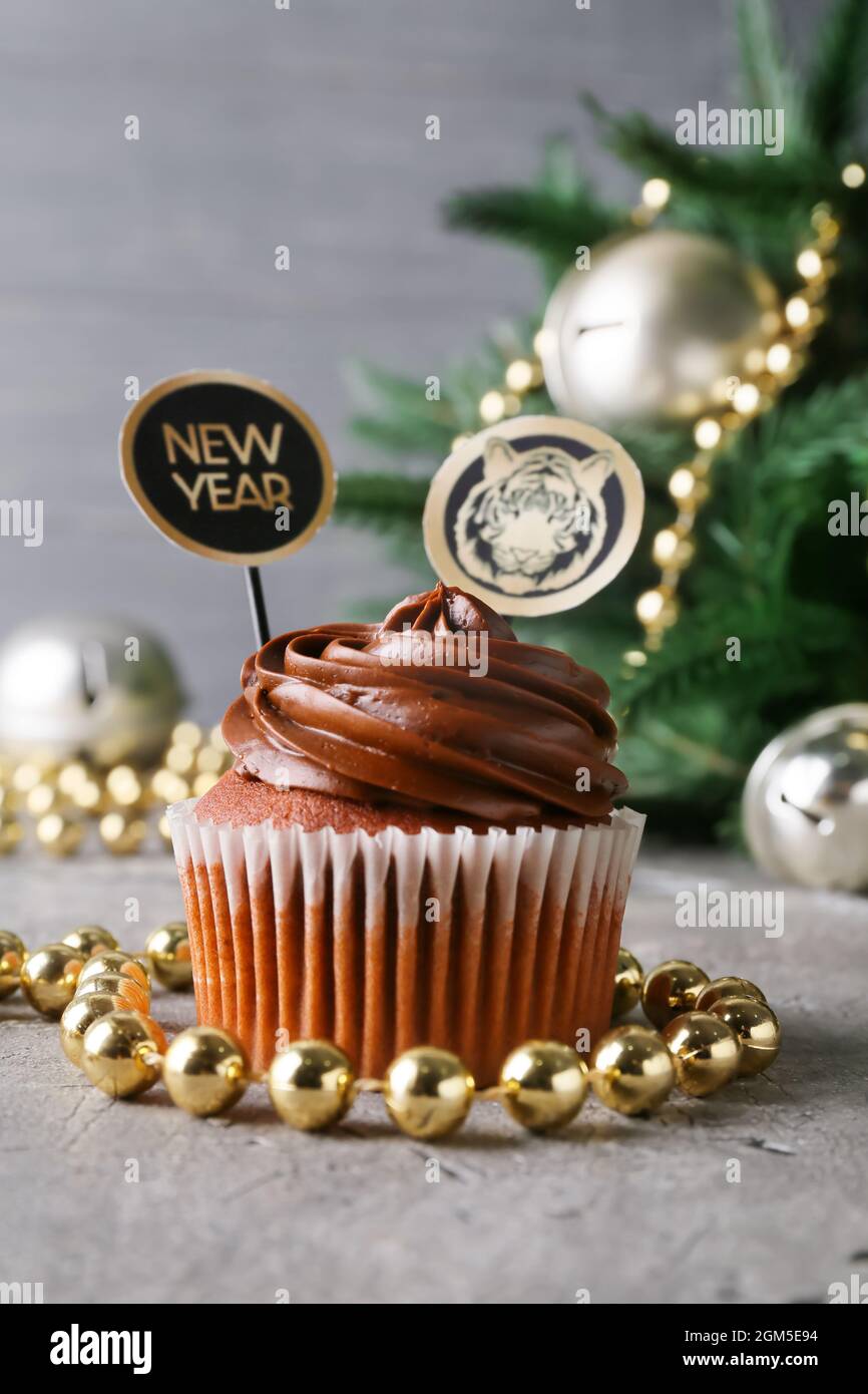Tasty cupcake for New Year 2022 celebration with decor on grunge ...