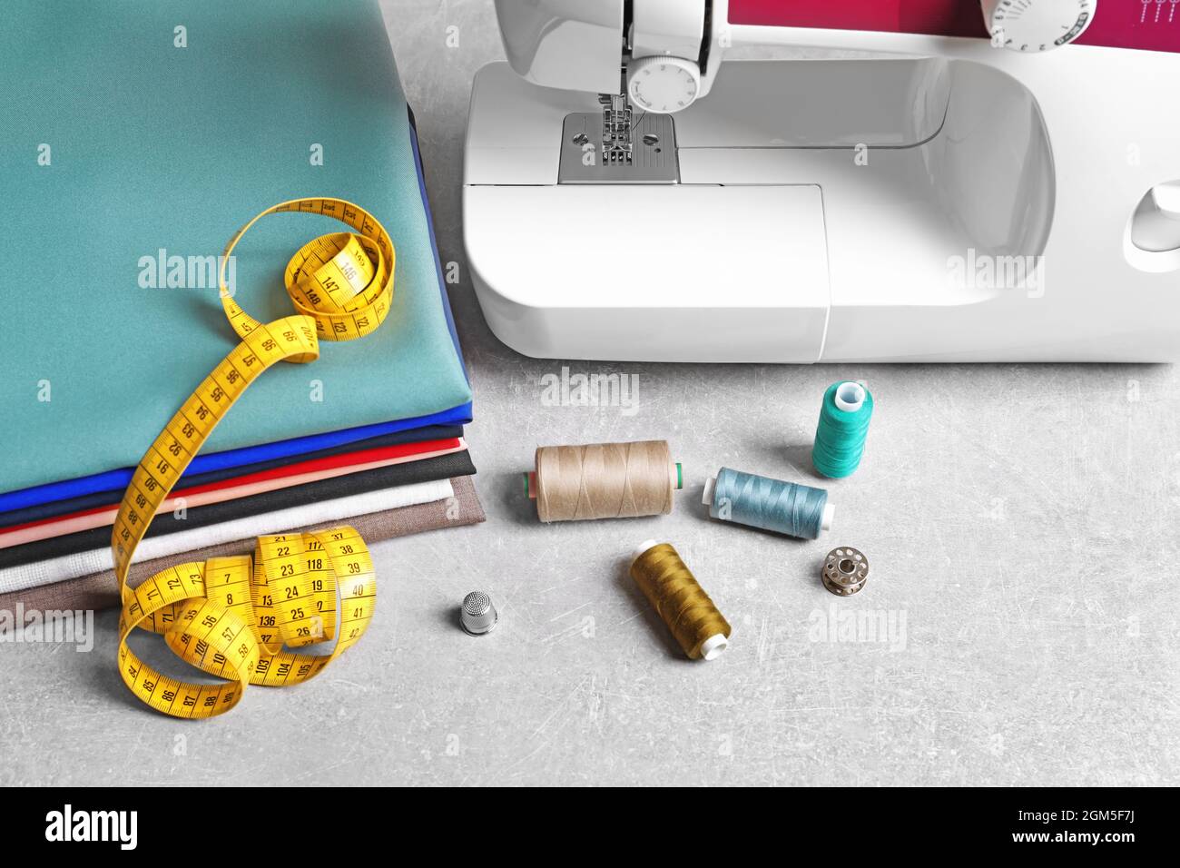 Set of tailoring tools, fabric and sewing machine on table Stock Photo ...