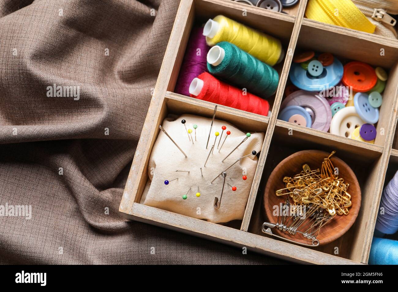 Storage box with set of tailoring items on fabric, top view Stock Photo ...