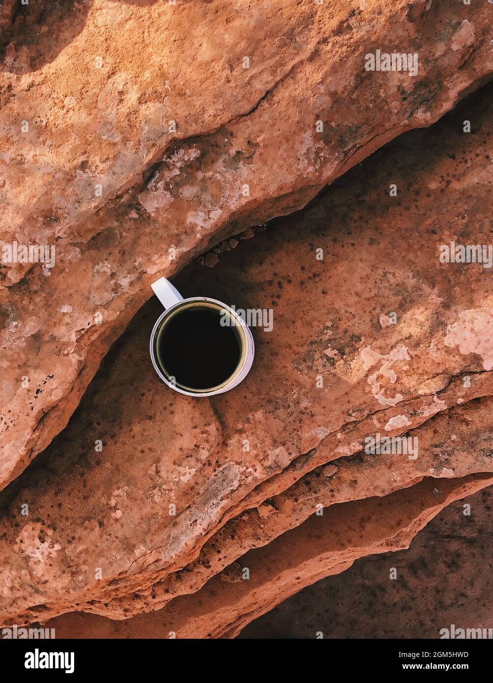Vertical shot of a cup of coffee on cliffs in the daylight Stock Photo ...