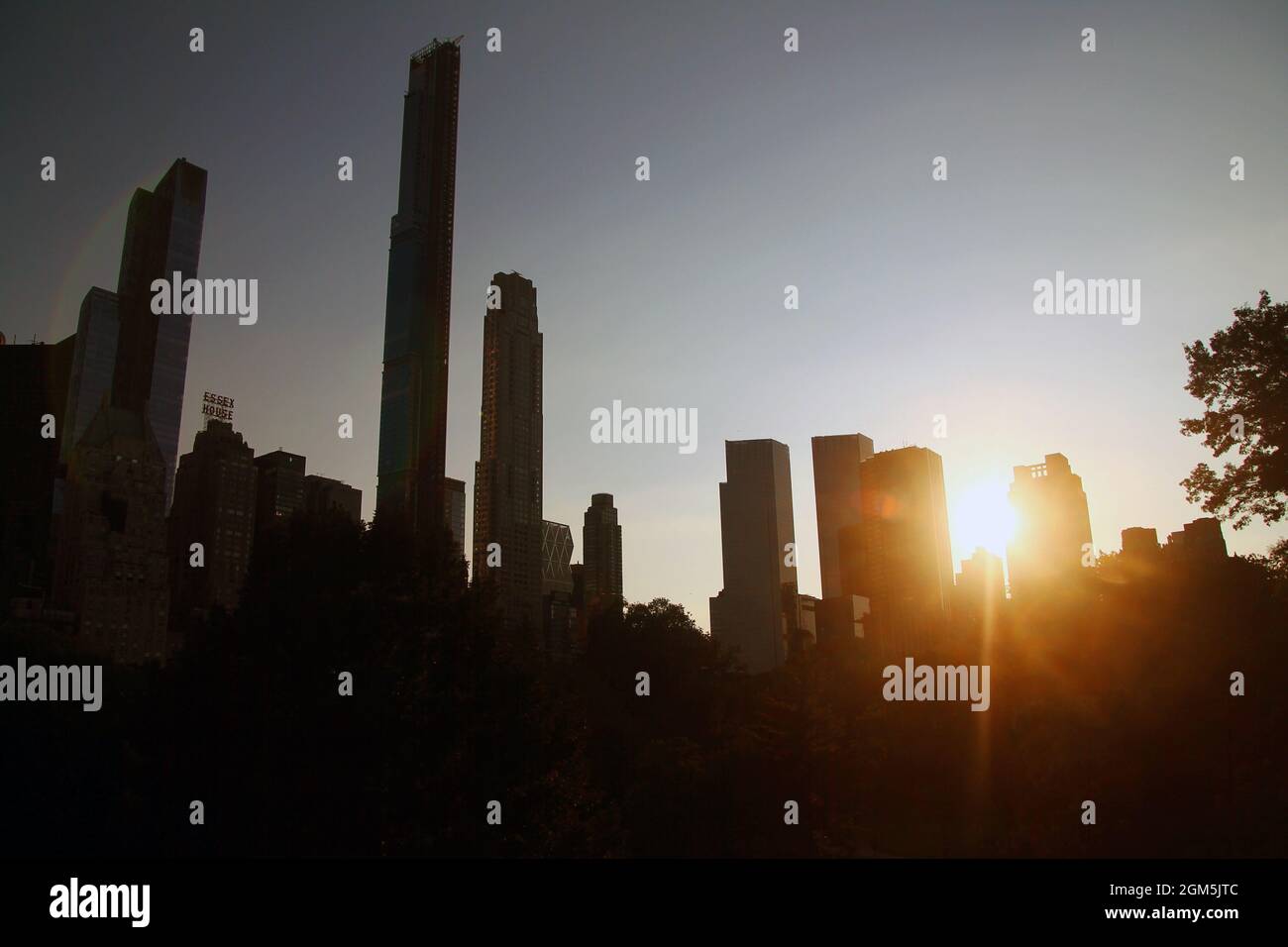 The sunset behind the skyscrapers from Central Park in New York City ...