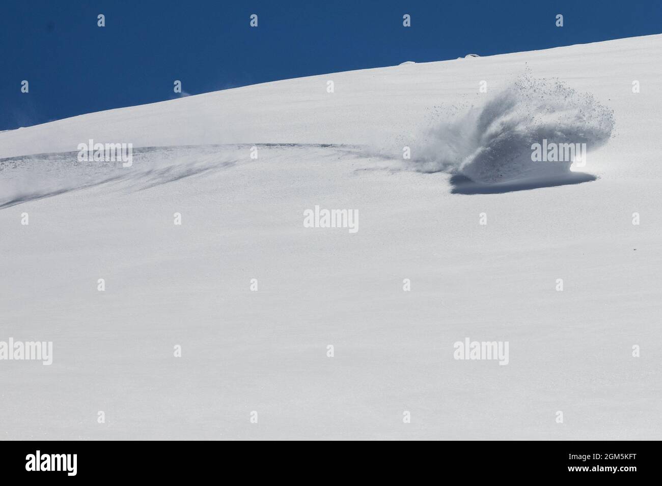 Snowboarder powder turn in fresh powder snow with deep blue sky in the ...