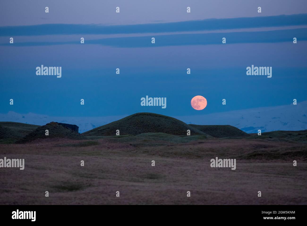 Full moon rise over Iceland glacier with rolling hills in the ...