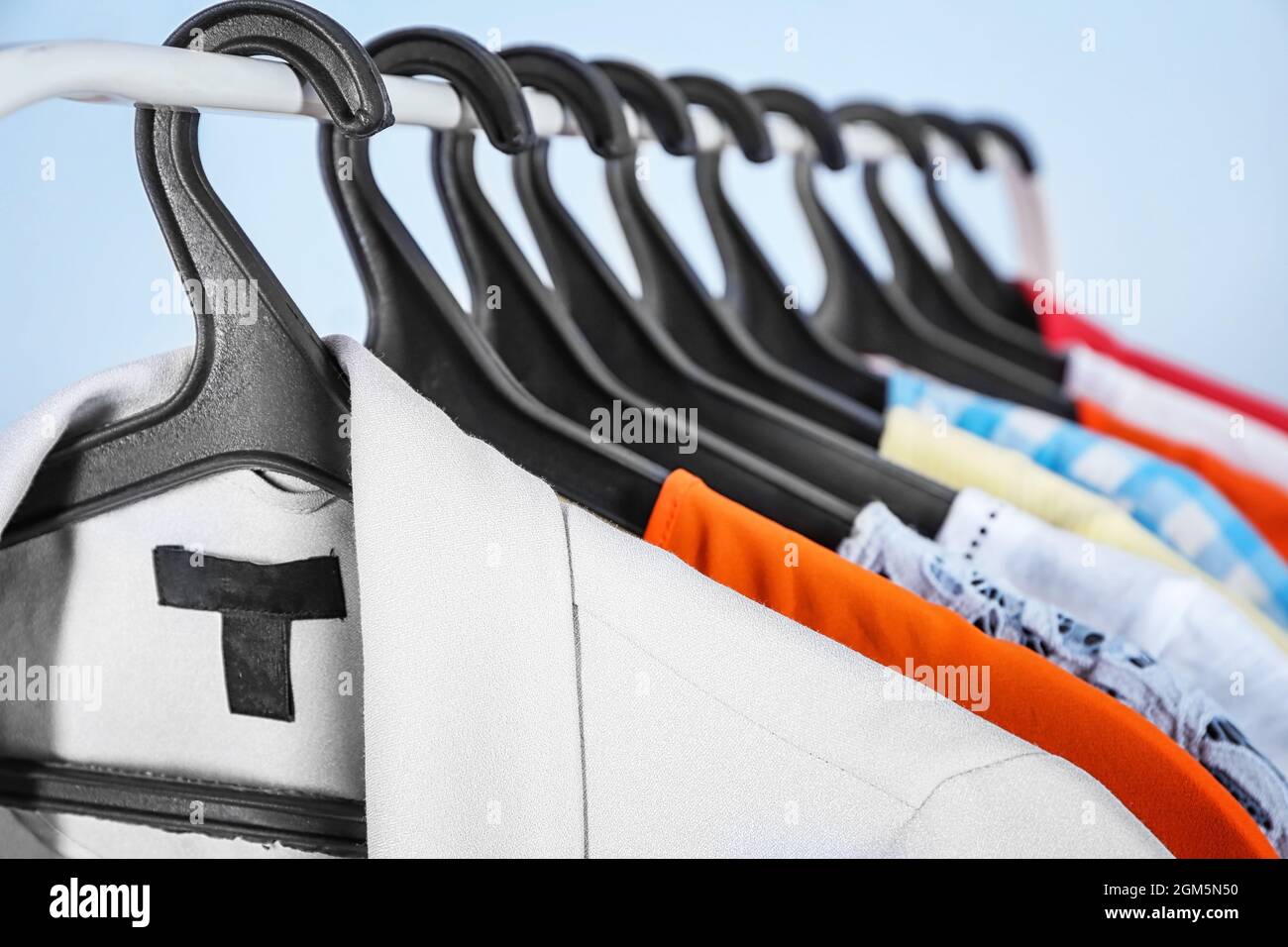 Clean clothes hanging on rack in laundry, closeup Stock Photo - Alamy