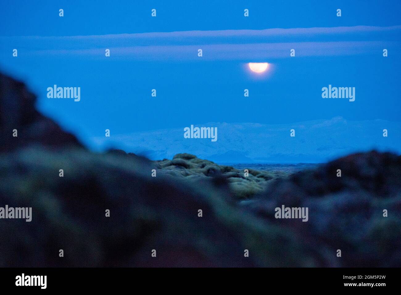 Full moon rising over a glacier in Iceland Stock Photo - Alamy