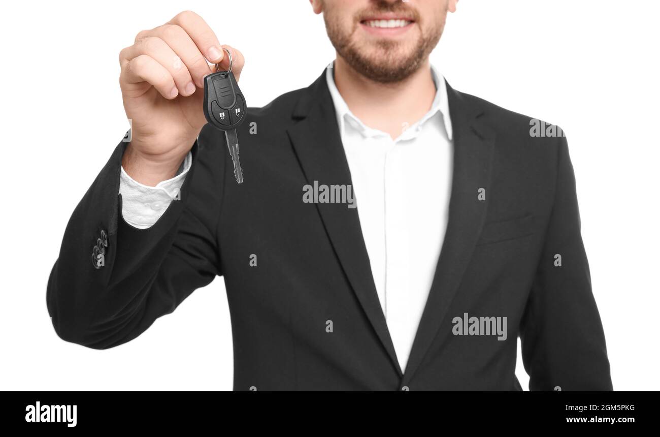 Man in formal suit holding car key on white background Stock Photo - Alamy