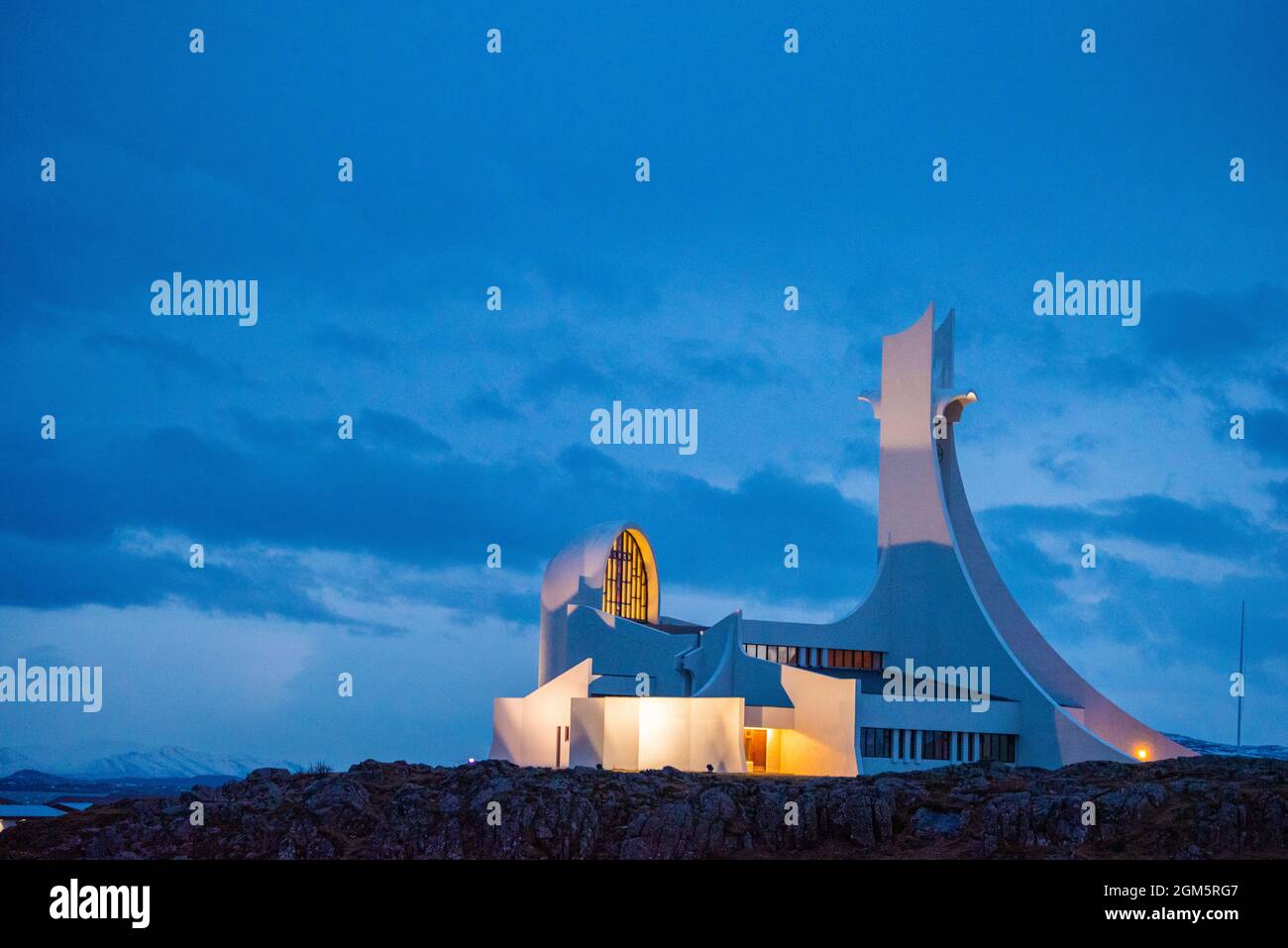 Geometric church building with yellow glowing interior lights and a ...