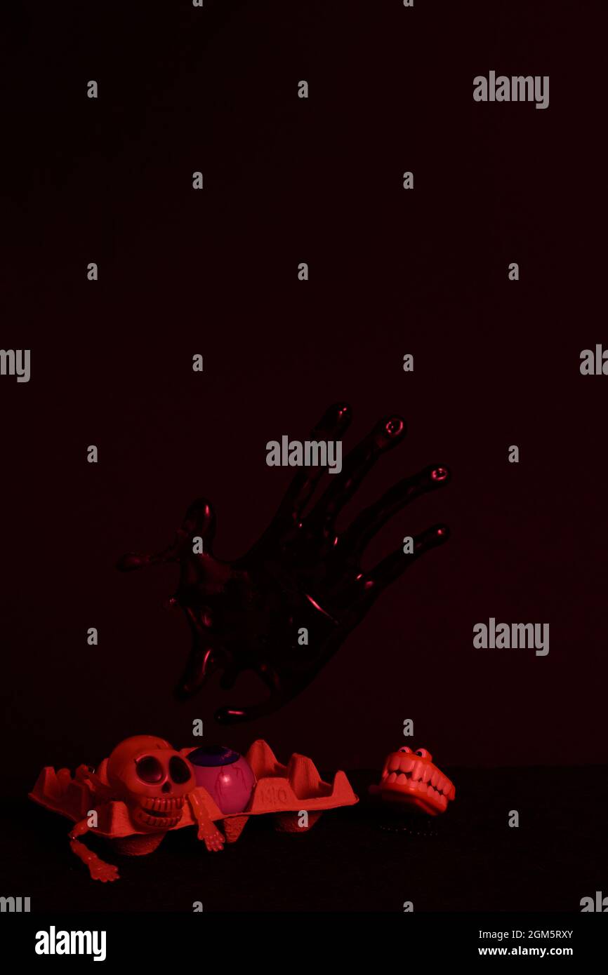A skull body and blue bloody eye in a egg cup tinted red in a black ...