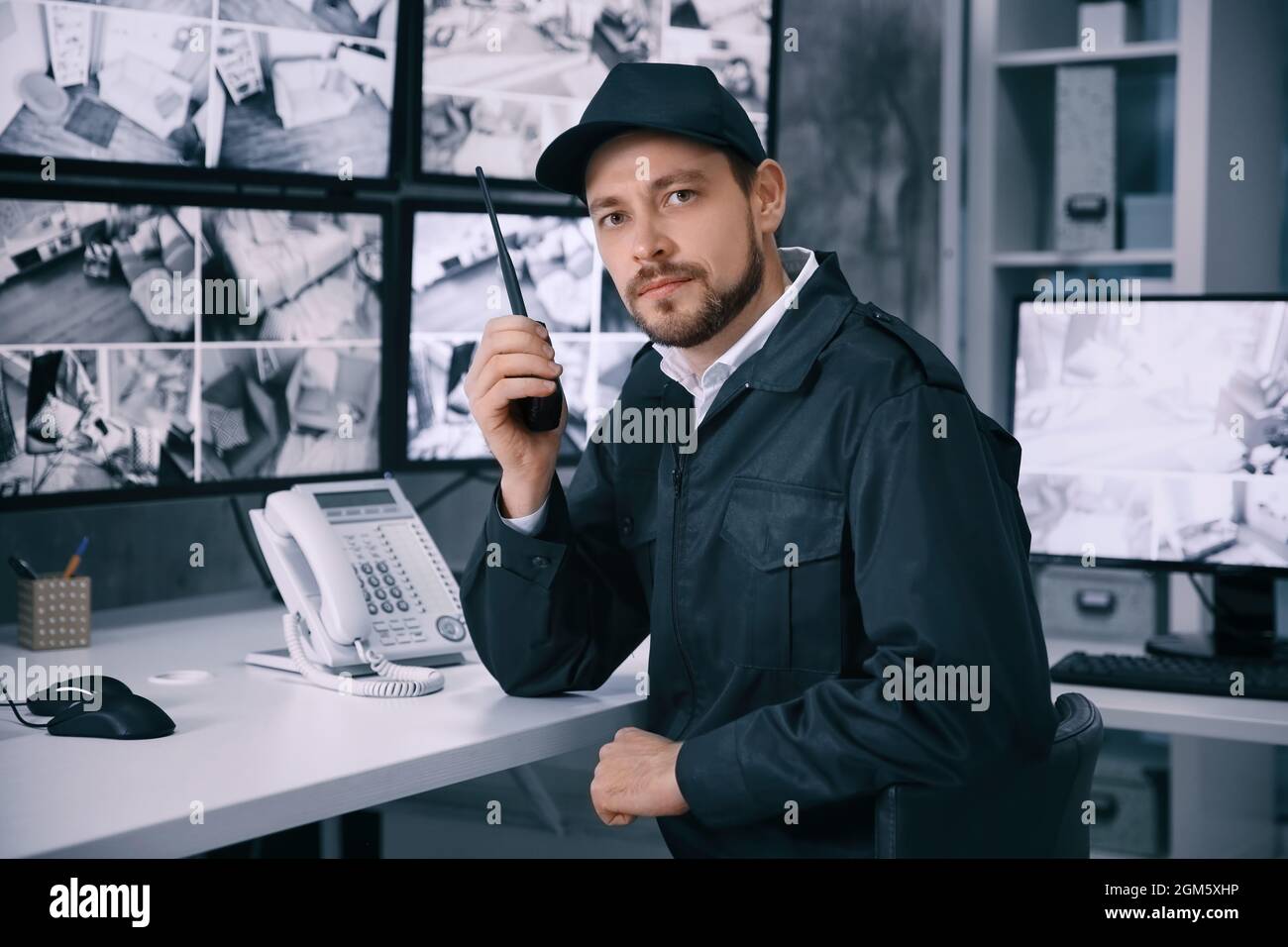 Male security guard using radio transmitter in surveillance room Stock ...