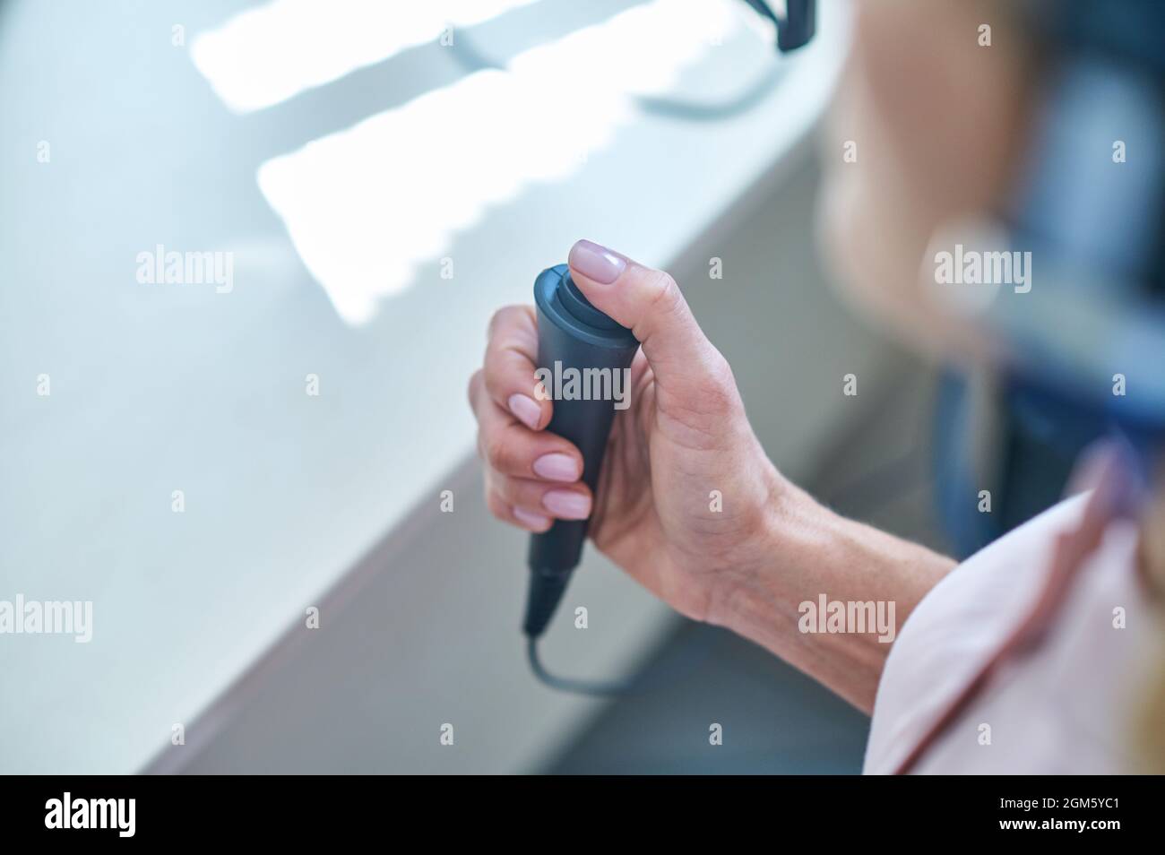 Female hand with remote control headphones Stock Photo - Alamy