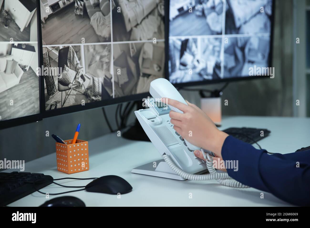 Female security guard using telephone in surveillance room Stock Photo ...