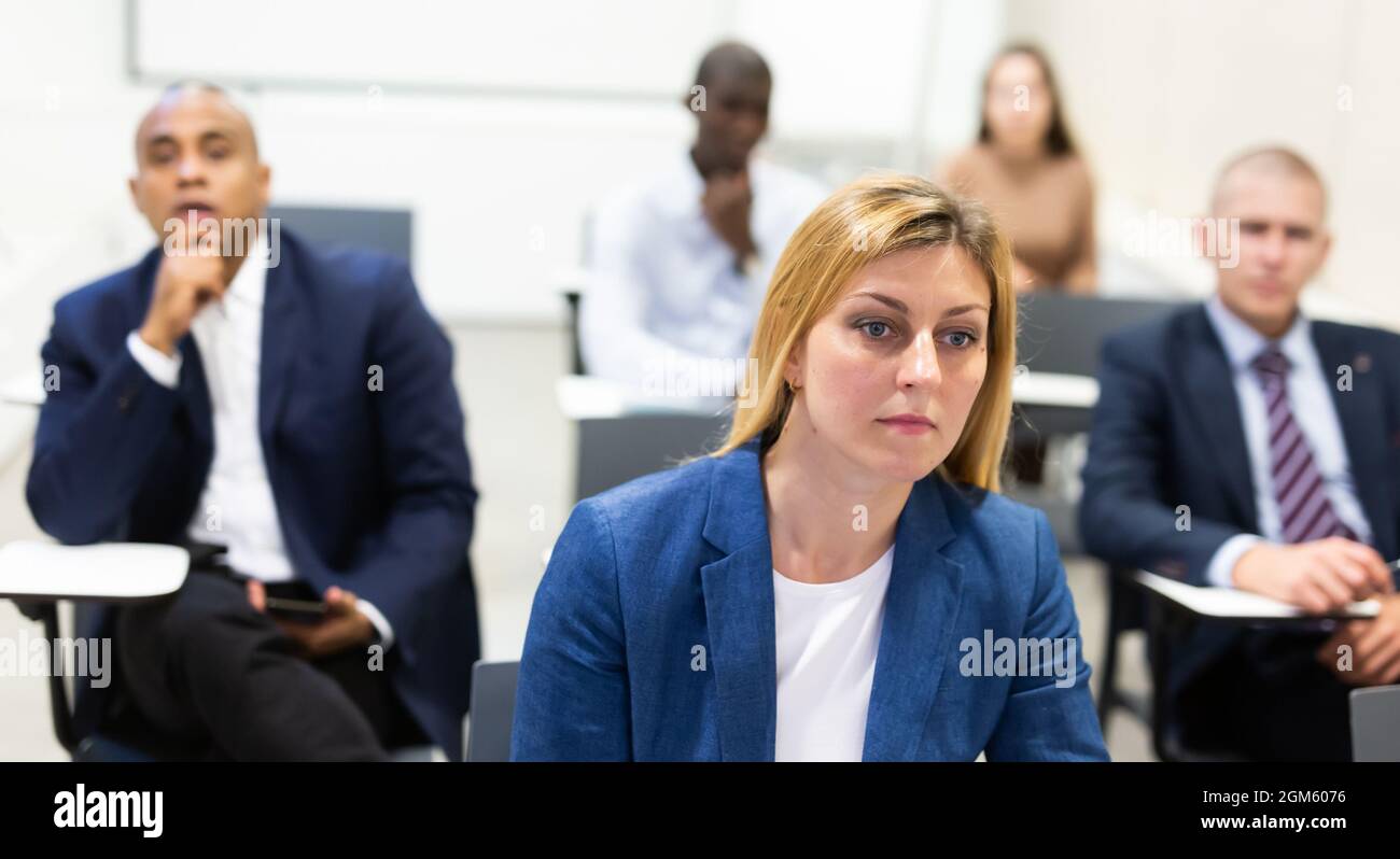 Young business woman sitting in conference hall at business event Stock ...