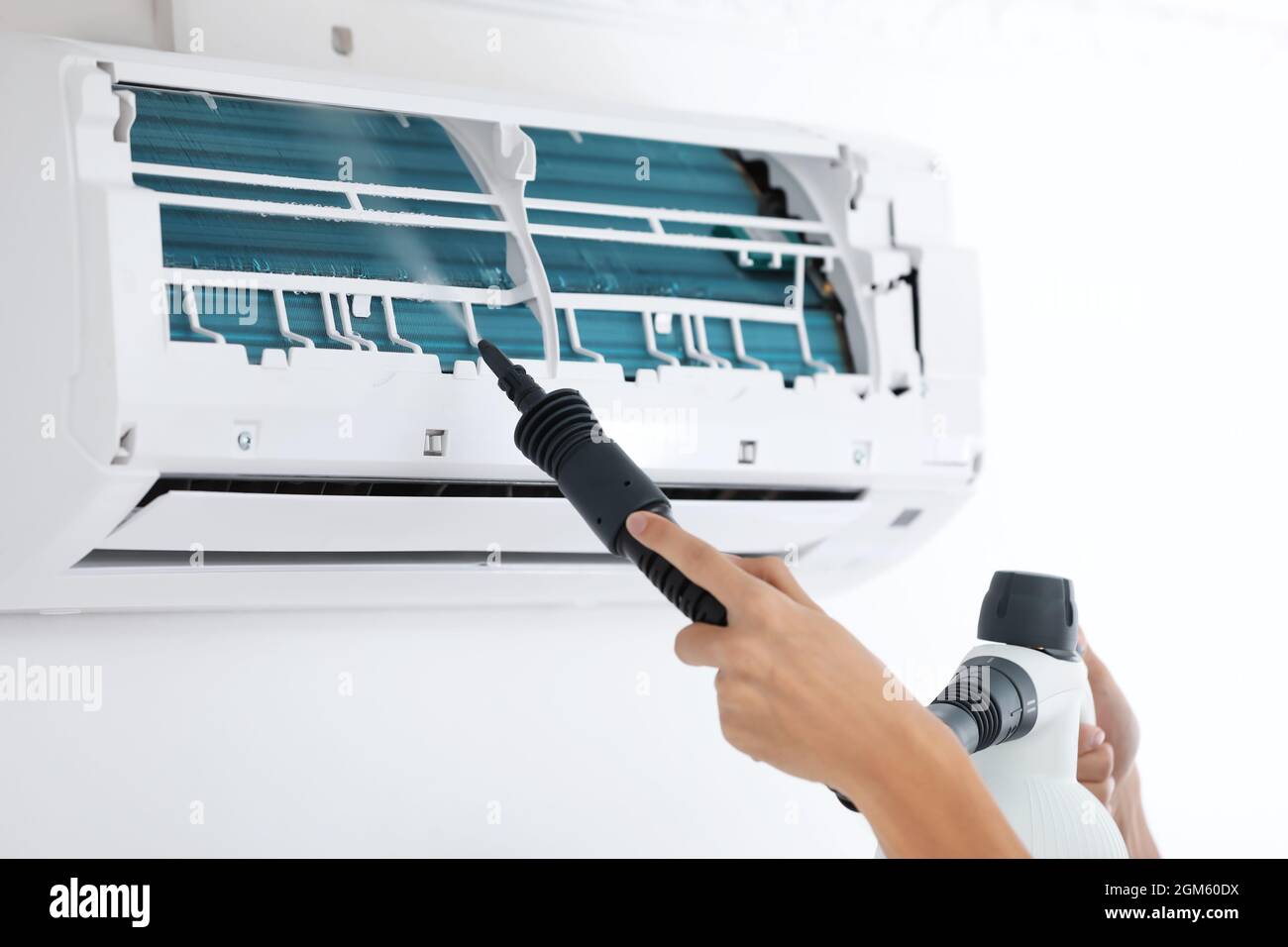 Man cleaning air conditioner indoors Stock Photo - Alamy