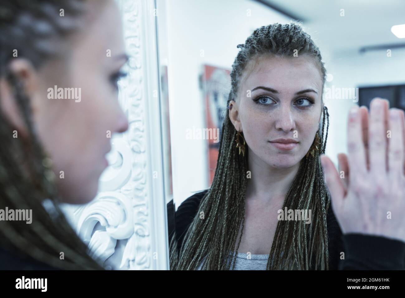 young girl with dreadlocks loves her image in the mirror imagining how ...
