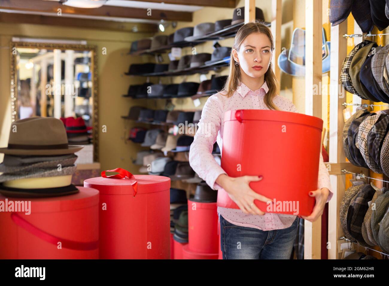 Shop assistant holding boxes with hats Stock Photo - Alamy