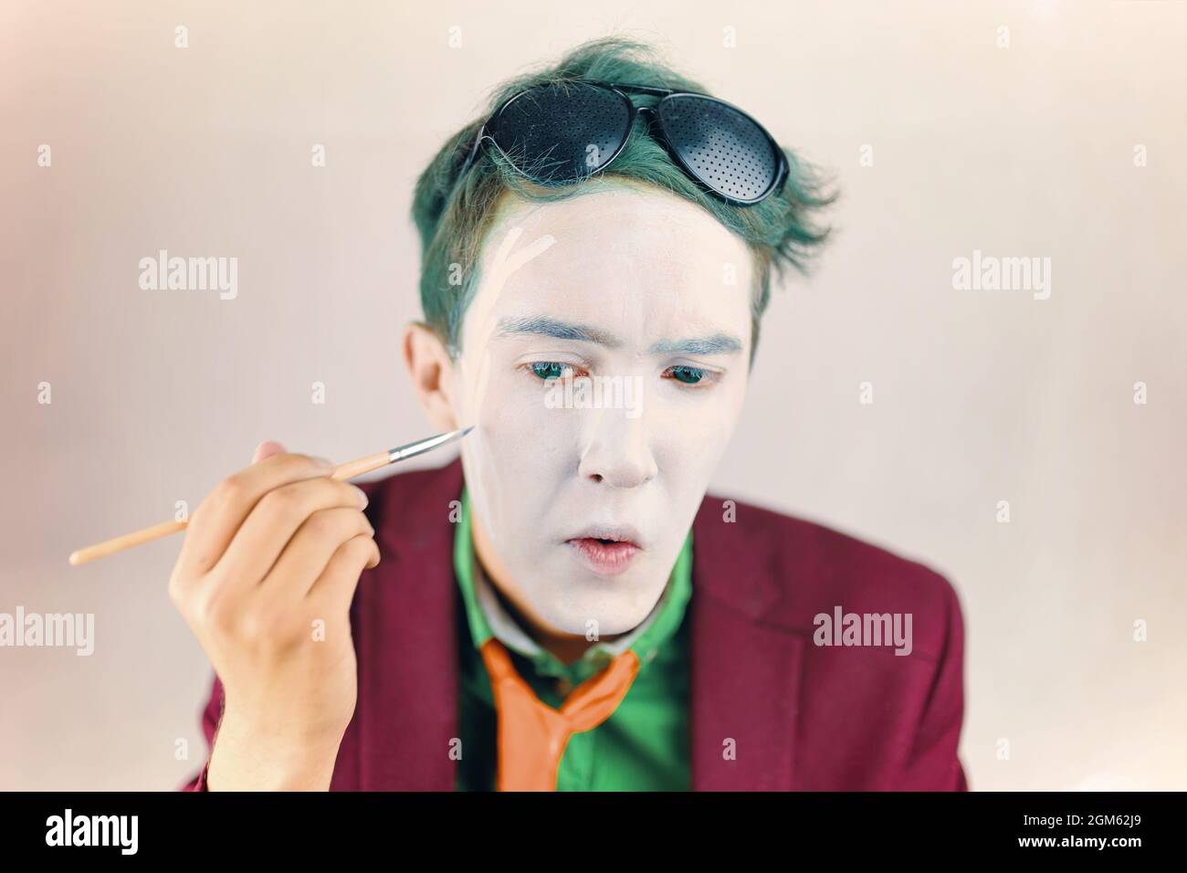 Mim is preparing for performance. Cosplayer paints his face with brush ...