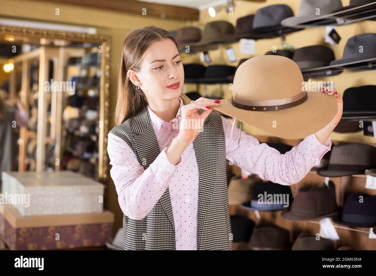 Woman choosing hat in store Stock Photo - Alamy