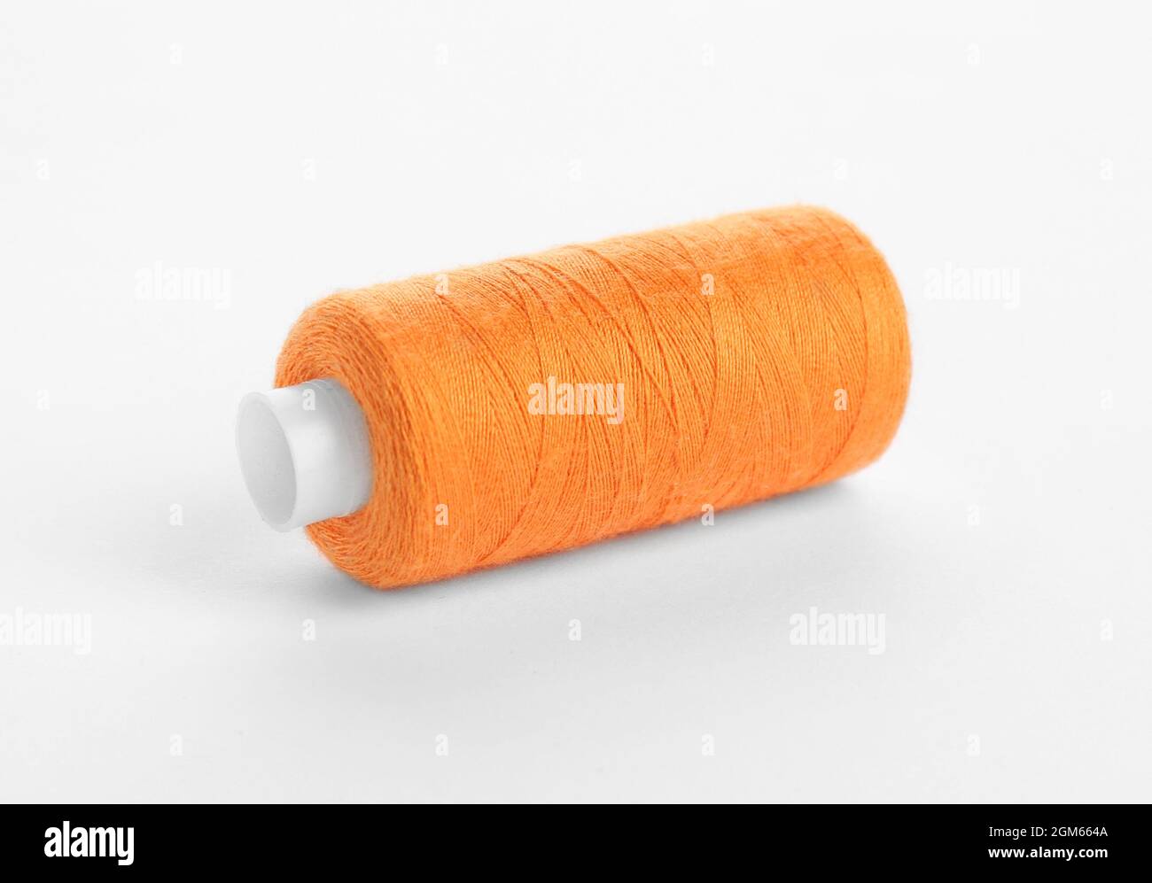 Spool of sewing thread on white background Stock Photo - Alamy