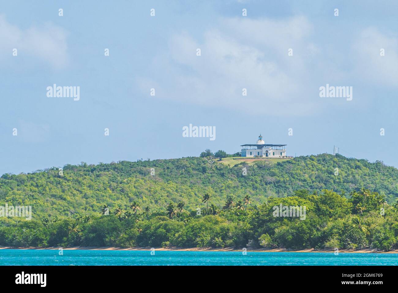 Lighthouse sits on a hill in Fajardo Puerto Rico surrounded by palm ...
