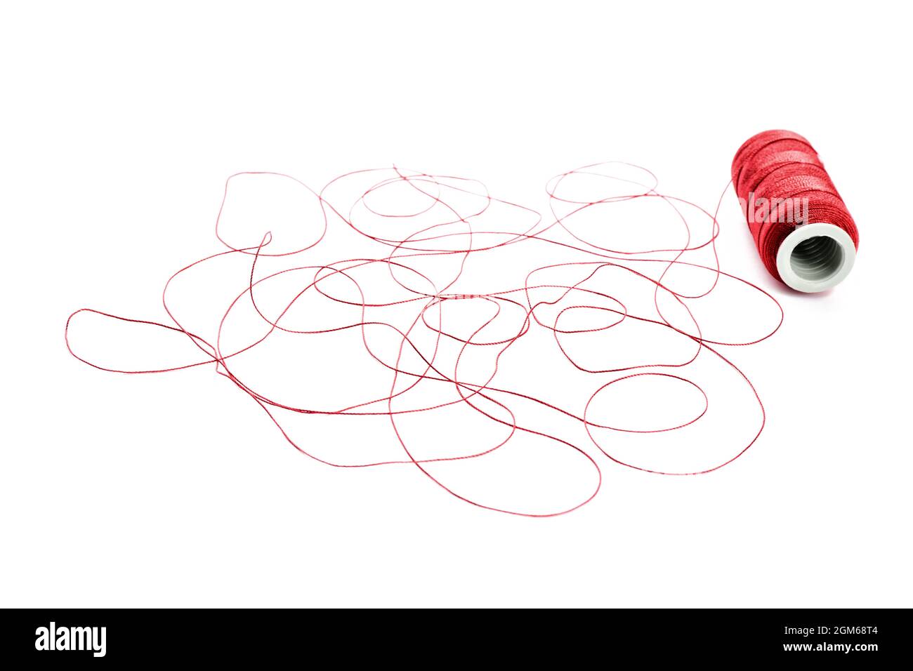 Spool of red thread on white background Stock Photo - Alamy