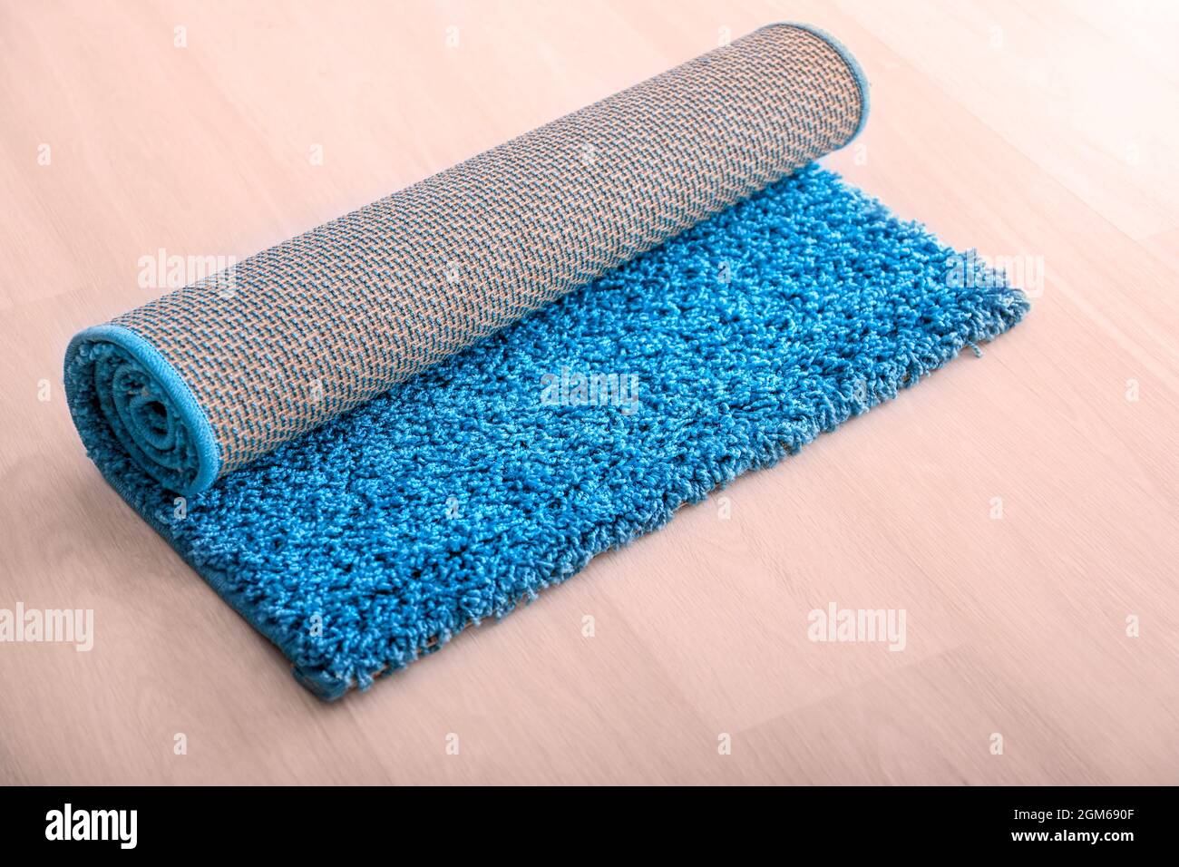 Rolled blue carpet on floor Stock Photo - Alamy