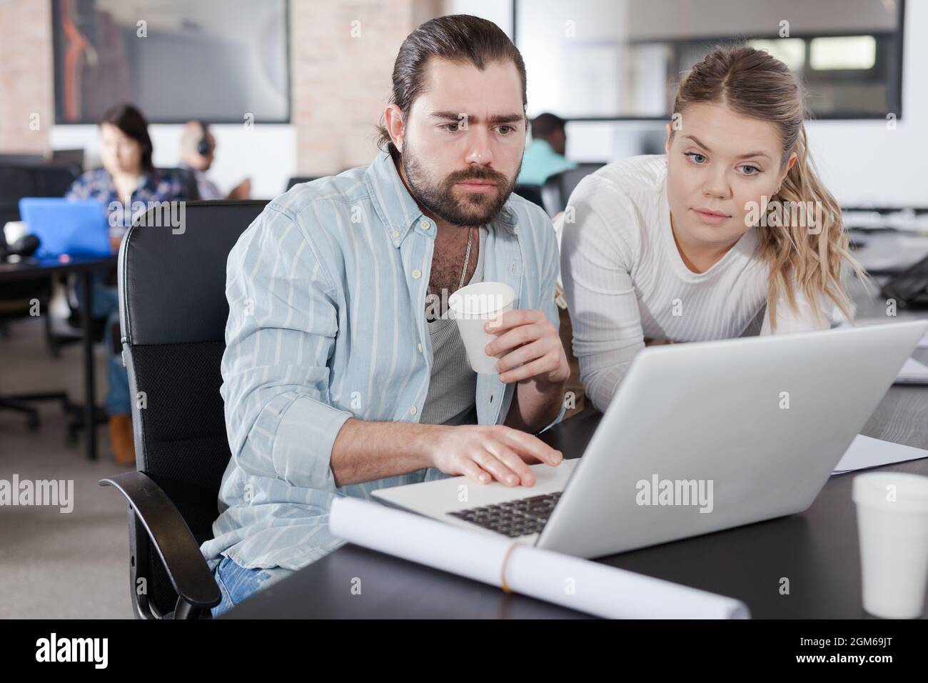 Woman explaining project to male coworker Stock Photo - Alamy