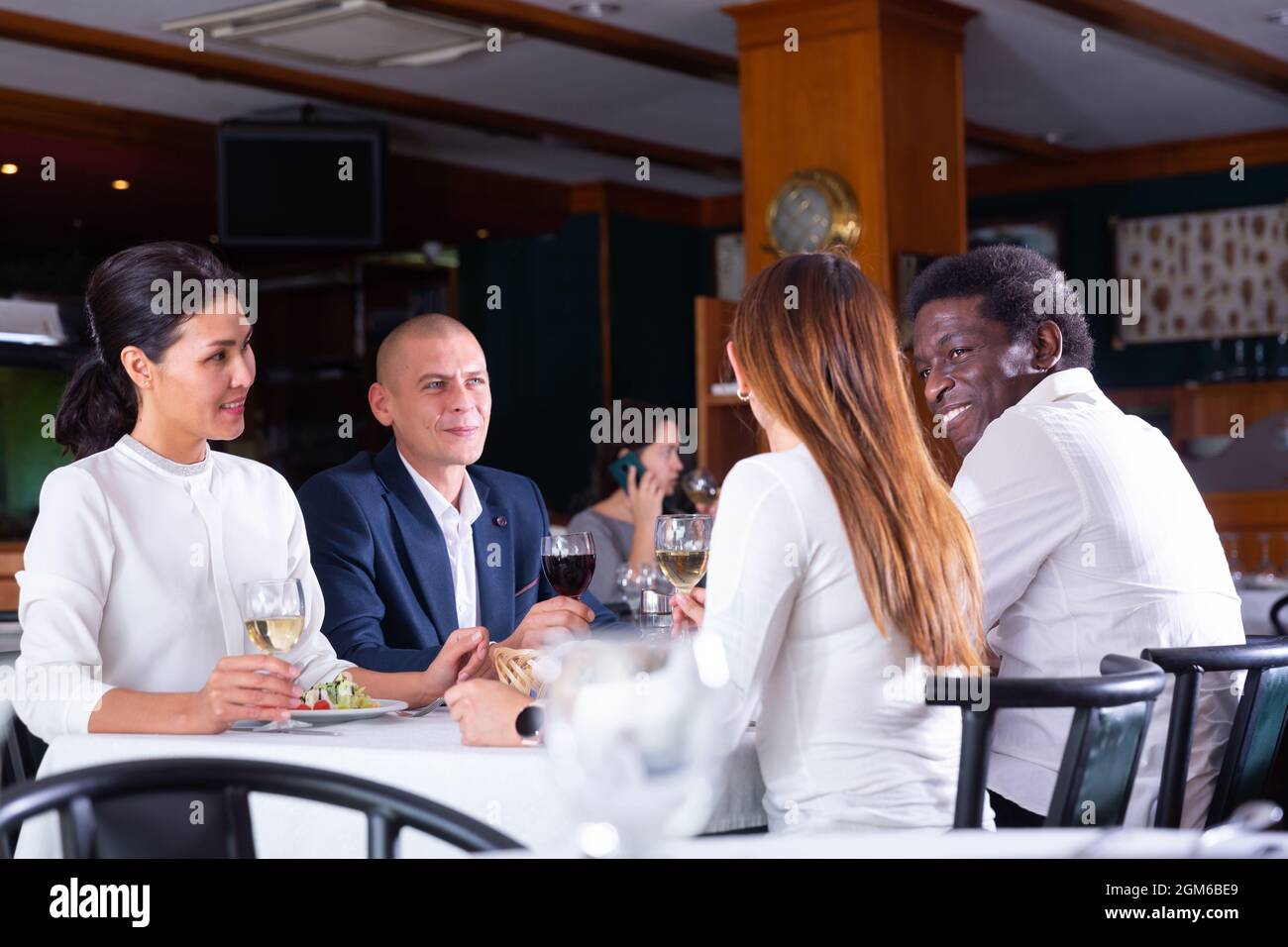 Group of people having dinner in cozy restaurant Stock Photo - Alamy